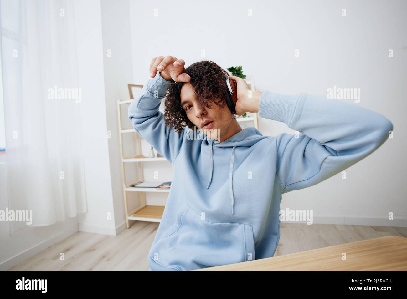 handsome guy in a blue jacket in headphones interior Stock Photo - Alamy
