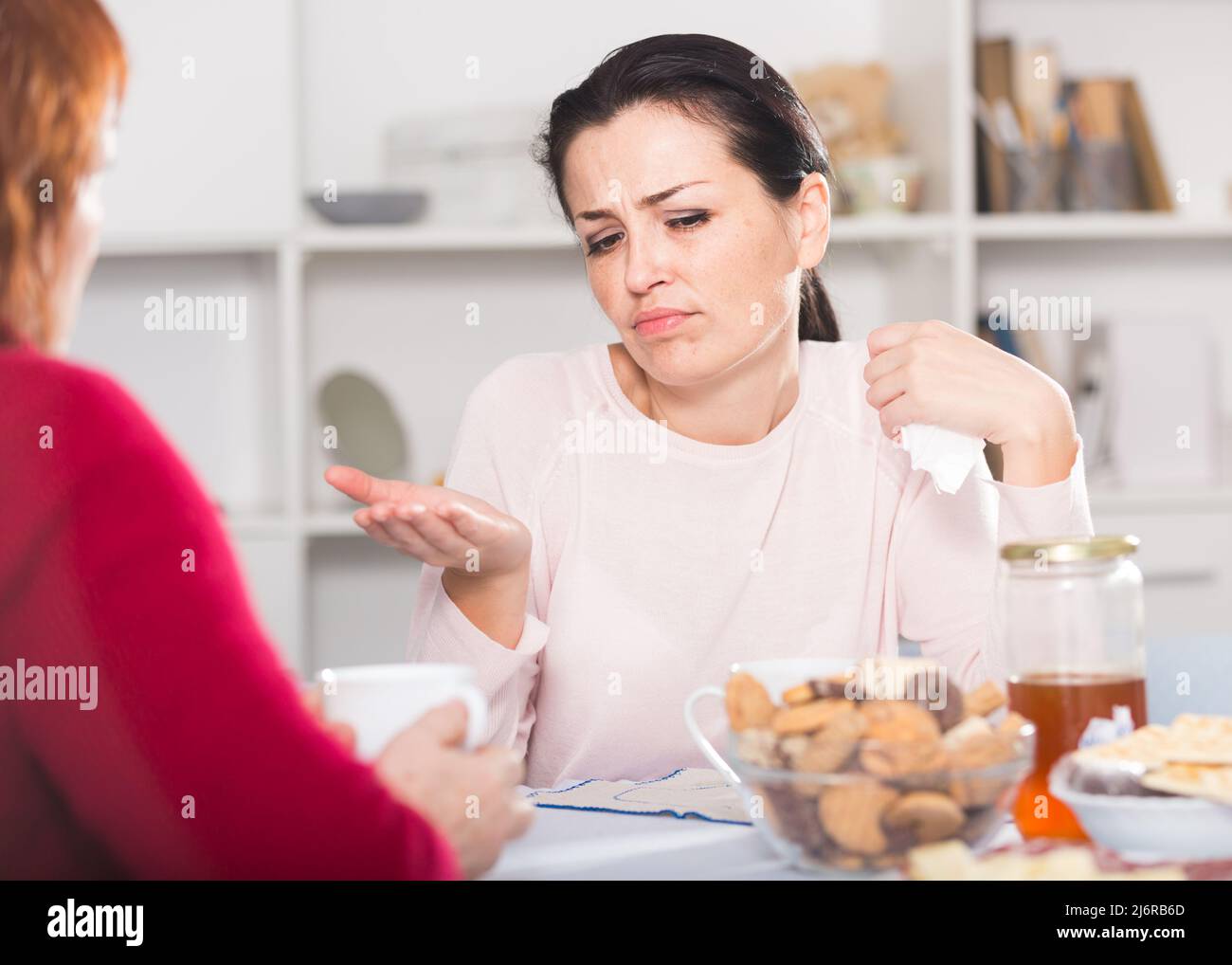 Portrait of sad female talking with mother at table Stock Photo - Alamy