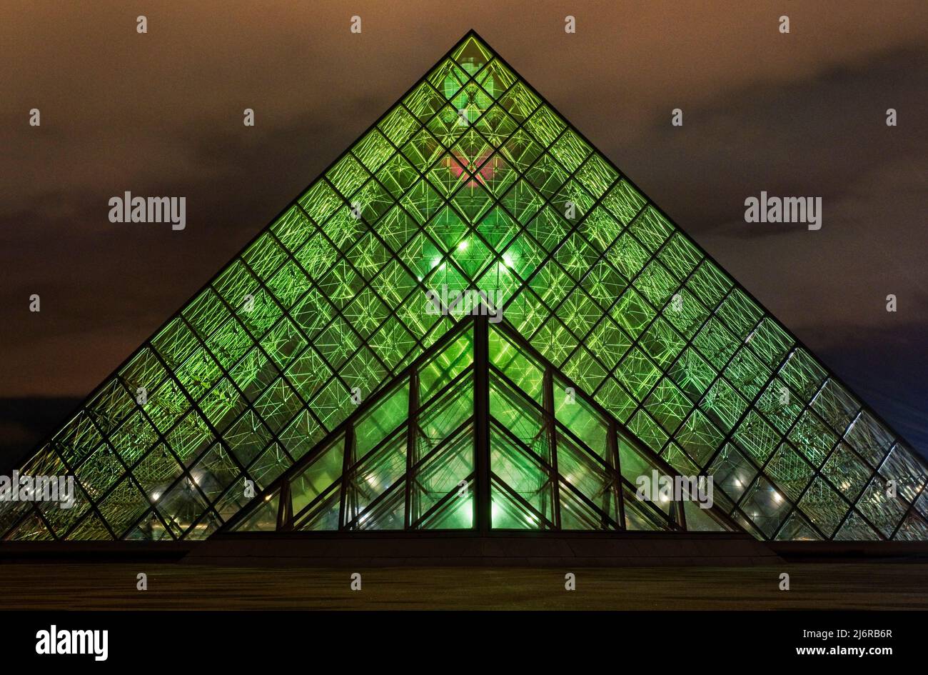 The musée du Louvre’s glass pyramid illuminated with green lights at ...