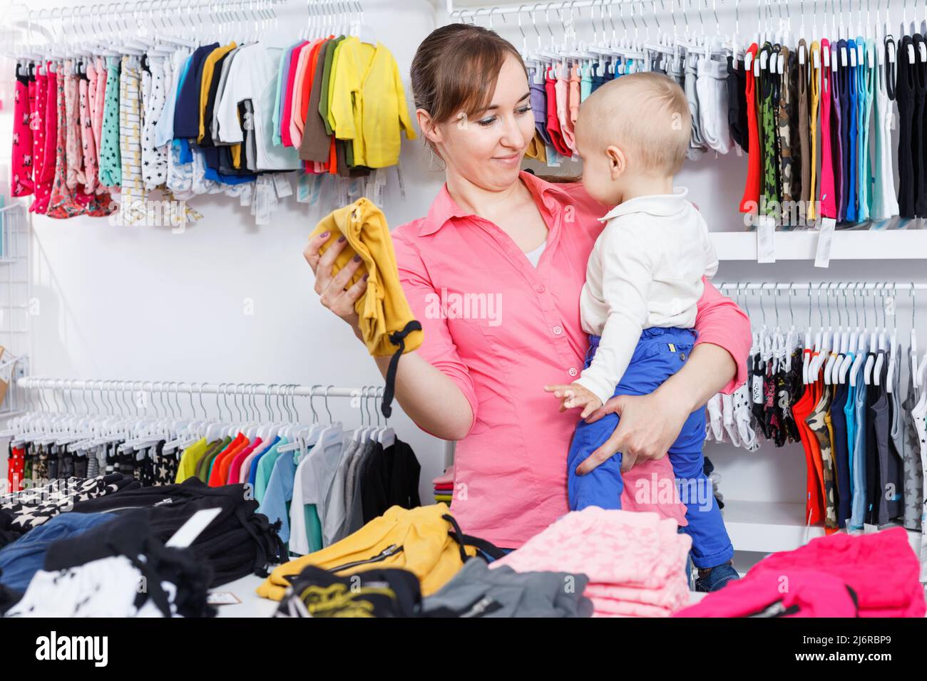 Female and her toddler are satisfied of shopping in the kid store Stock ...