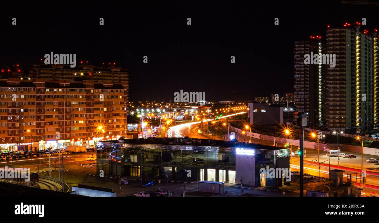 Night city lights. Crossroads with passing cars, lanterns and tall ...
