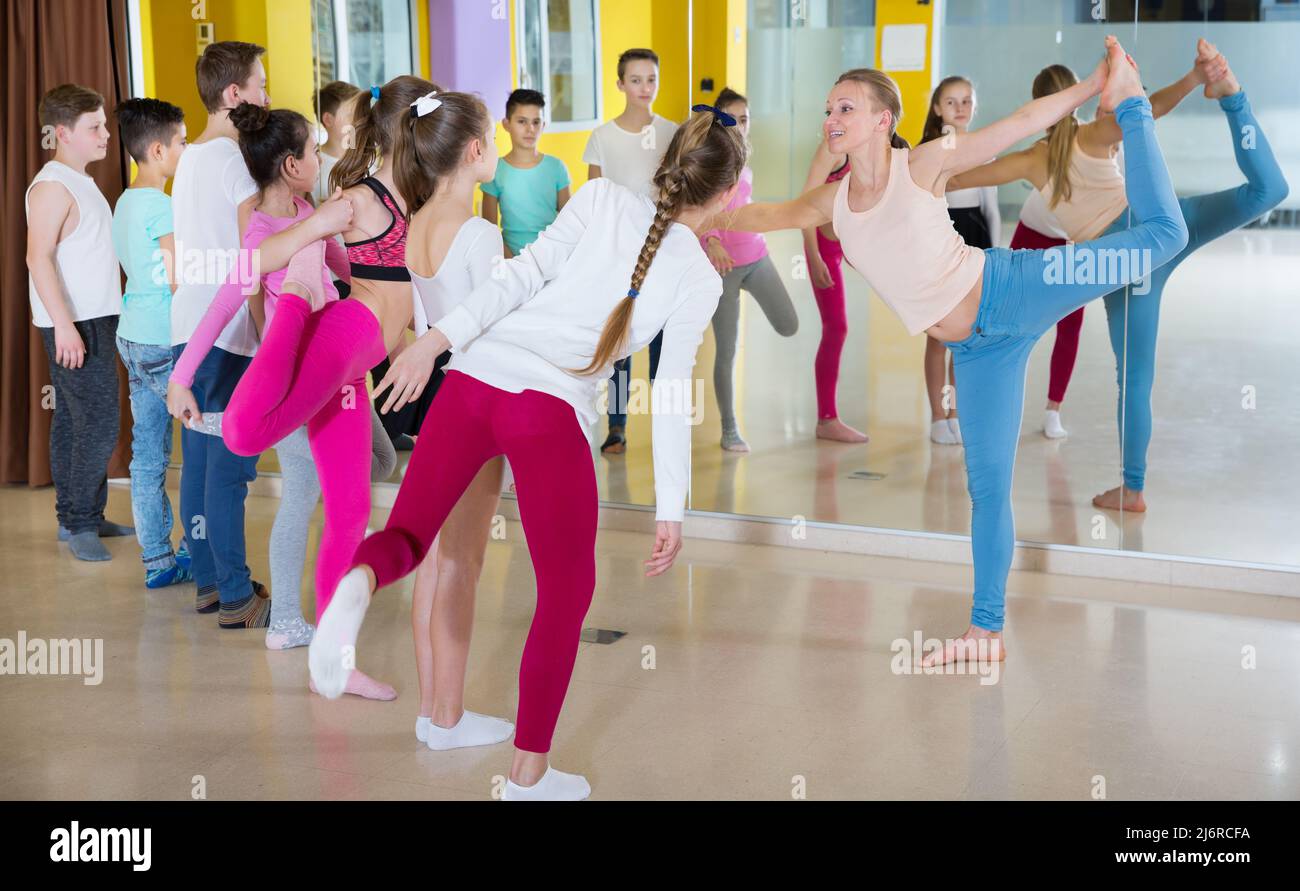 Teenagers with choreographer doing leg-split and crab position Stock ...