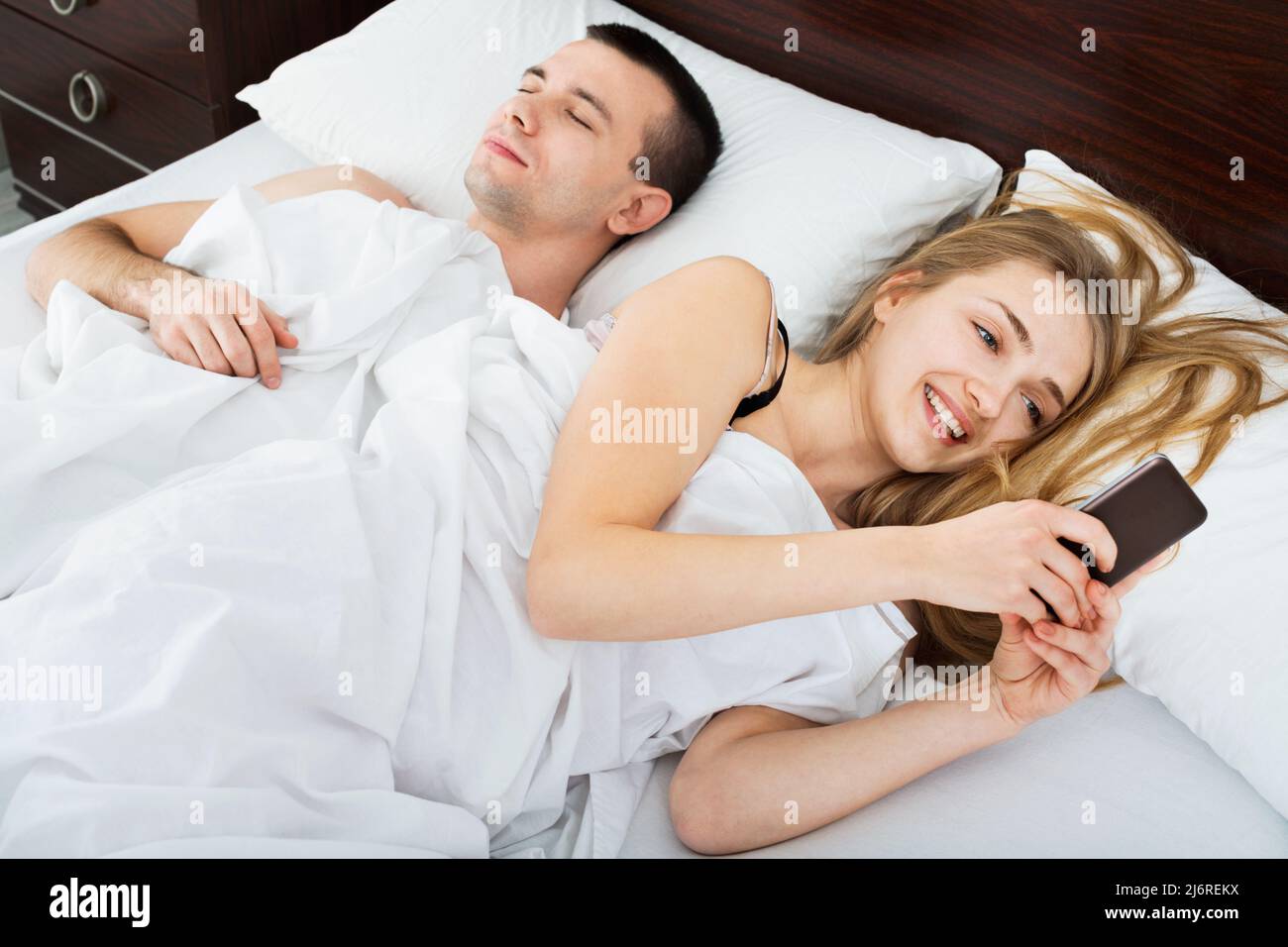 Beautiful young wife texting with lover on smartphone Stock Photo - Alamy