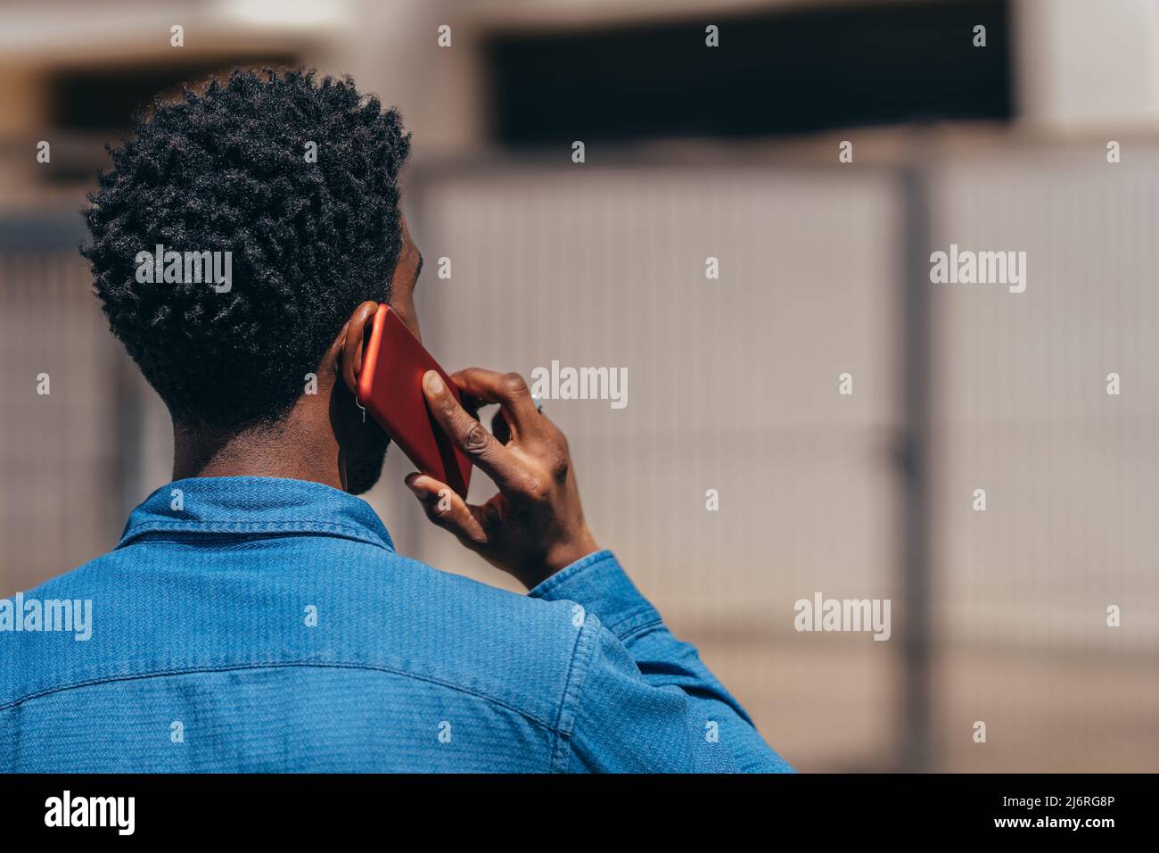 young Afro man talking on his cell phone as seen from behind Stock ...