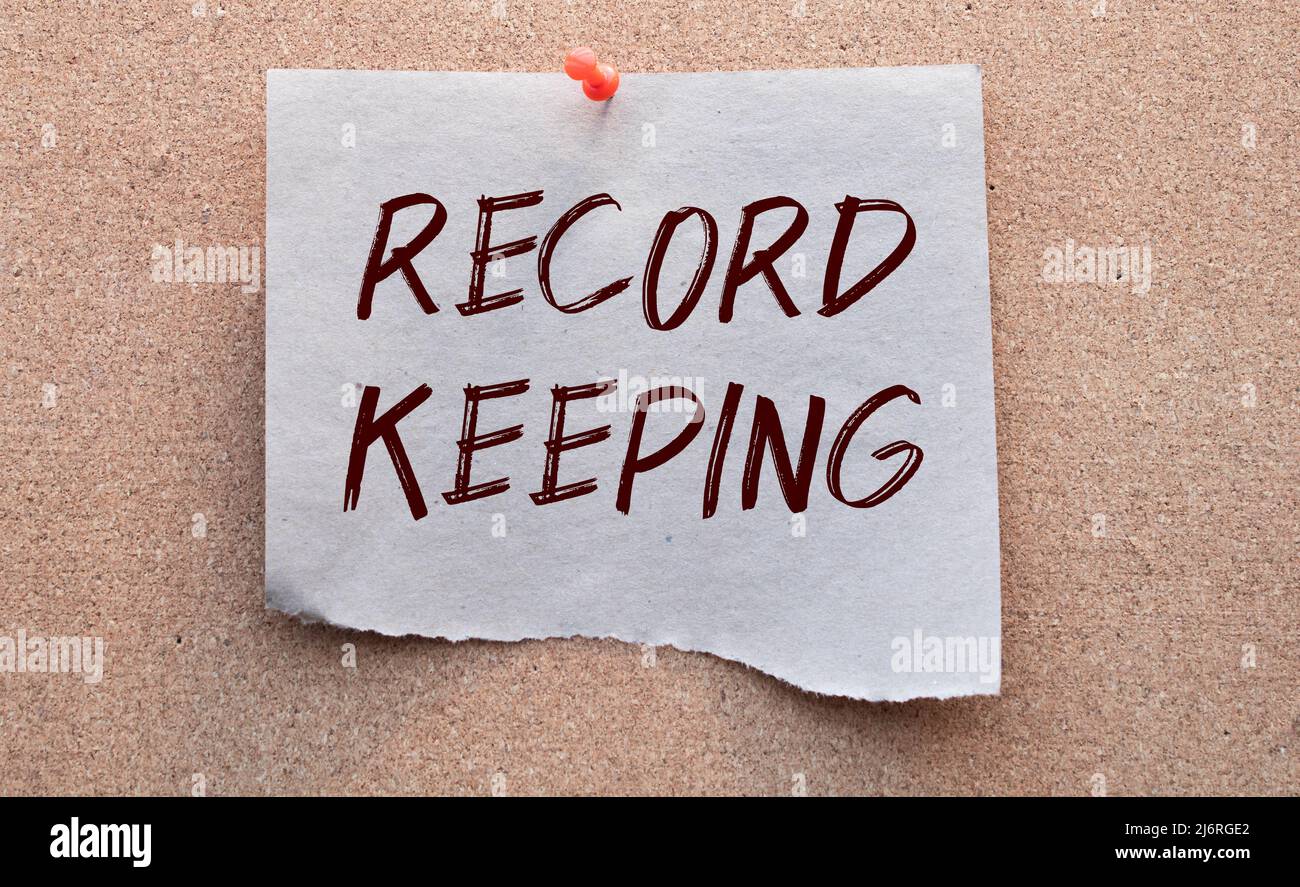 text record keeping on white paper card, black ahd red letters. lens on ...