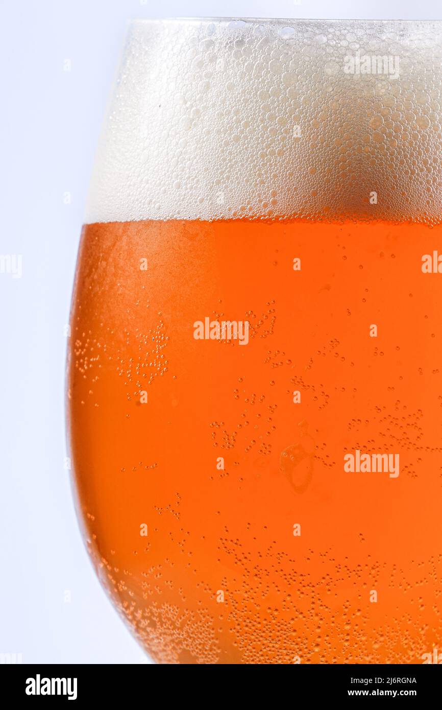 Detail glass of beer with droplets of condensation, bubbles and foam ...