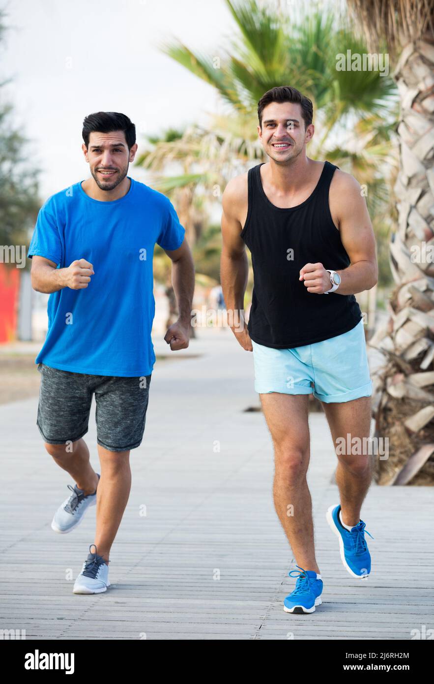 Two friends running into the ocean hi-res stock photography and images ...