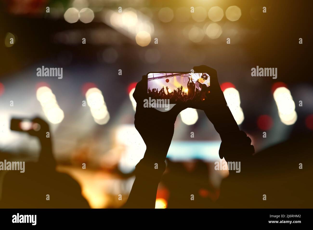 Music band fan holding the smart phone for photographing a concert ...