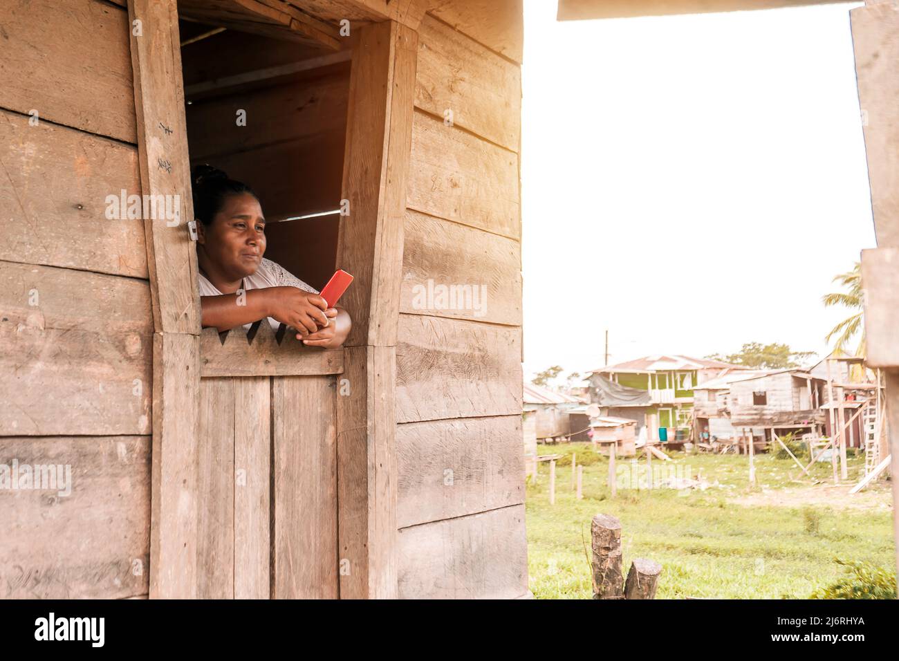 Mestizo woman inside her wooden house in a rural community in the Caribbean of Nicaragua using ...