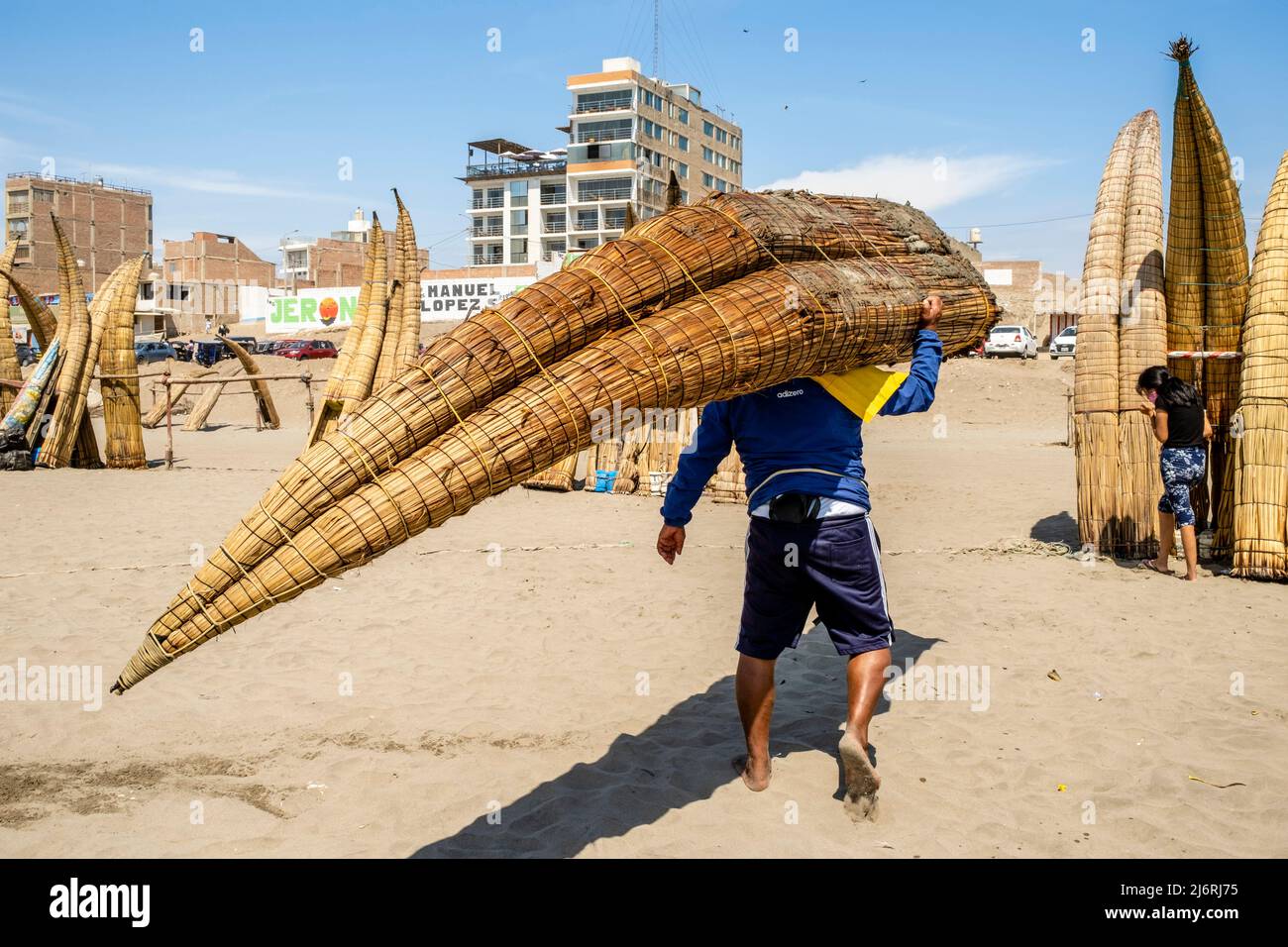 A Fisherman Carrying A Caballito de Totoro (Traditional Reed Boat ...