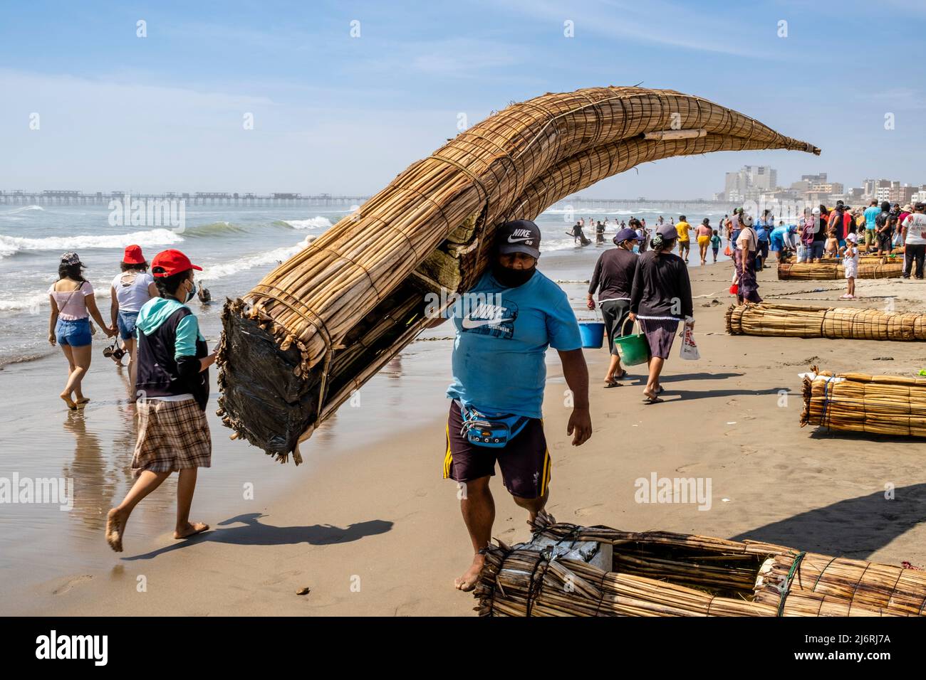 A Fisherman Carrying A Caballito de Totoro (Traditional Reed Boat ...