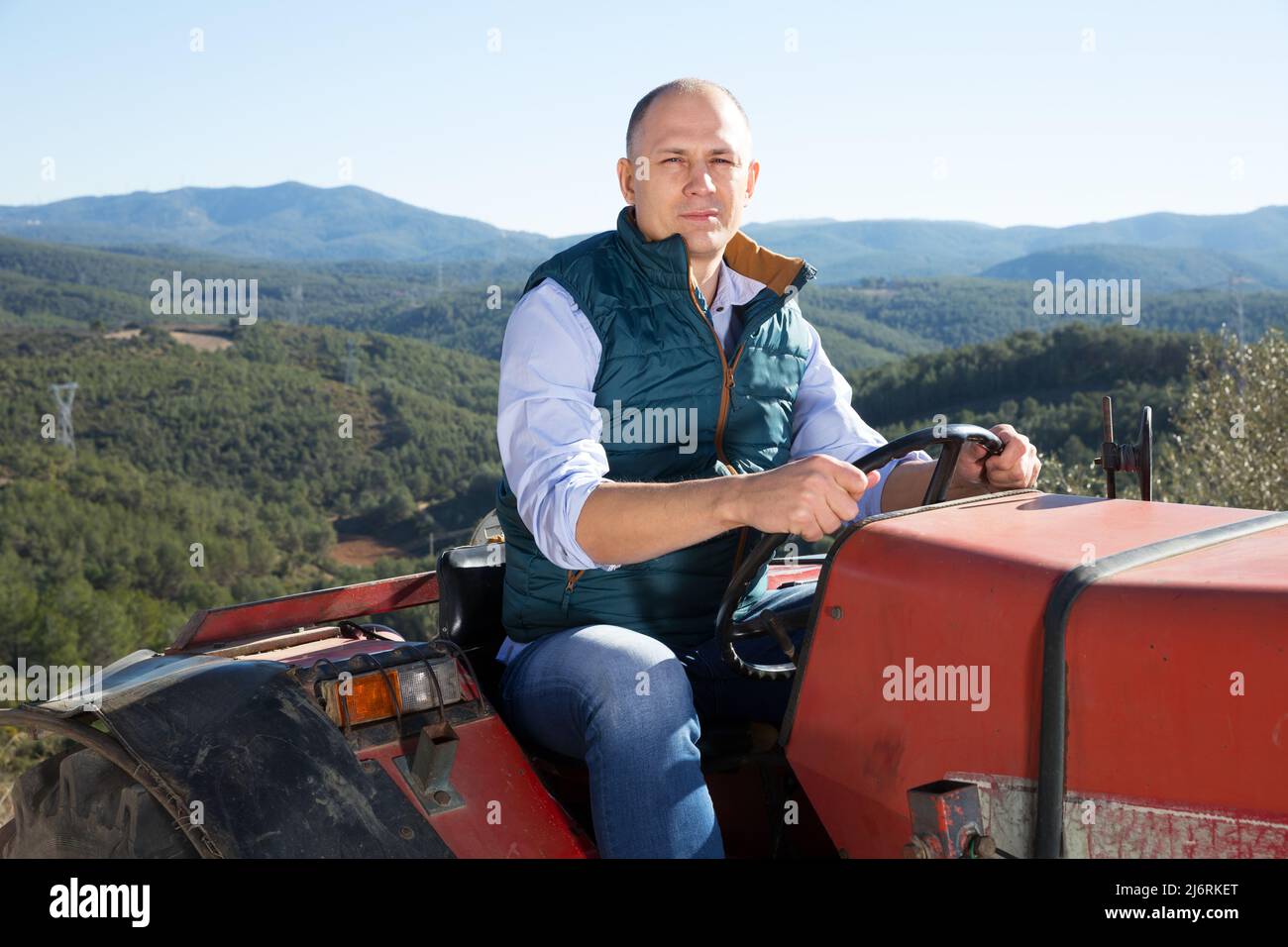 Farmer sitting in tractor Stock Photo - Alamy