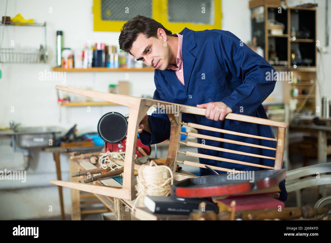 Craftsman repairing chair in workshop Stock Photo - Alamy