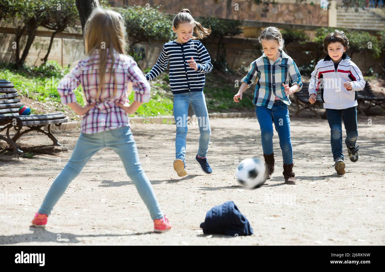 Kids playing street football Stock Photo - Alamy