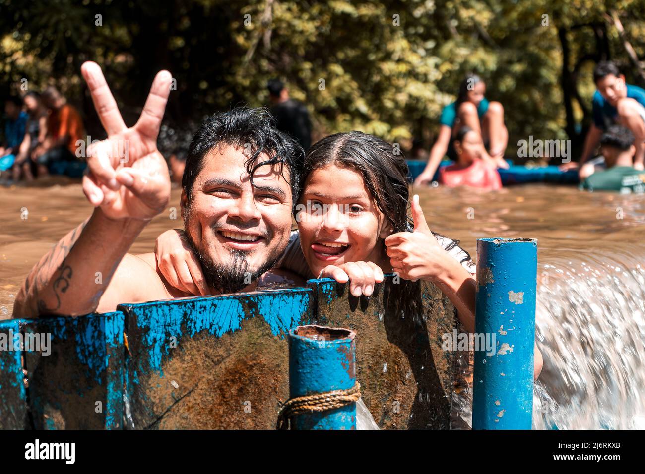 Father and daughter looking at the camera and making a peace gesture ...