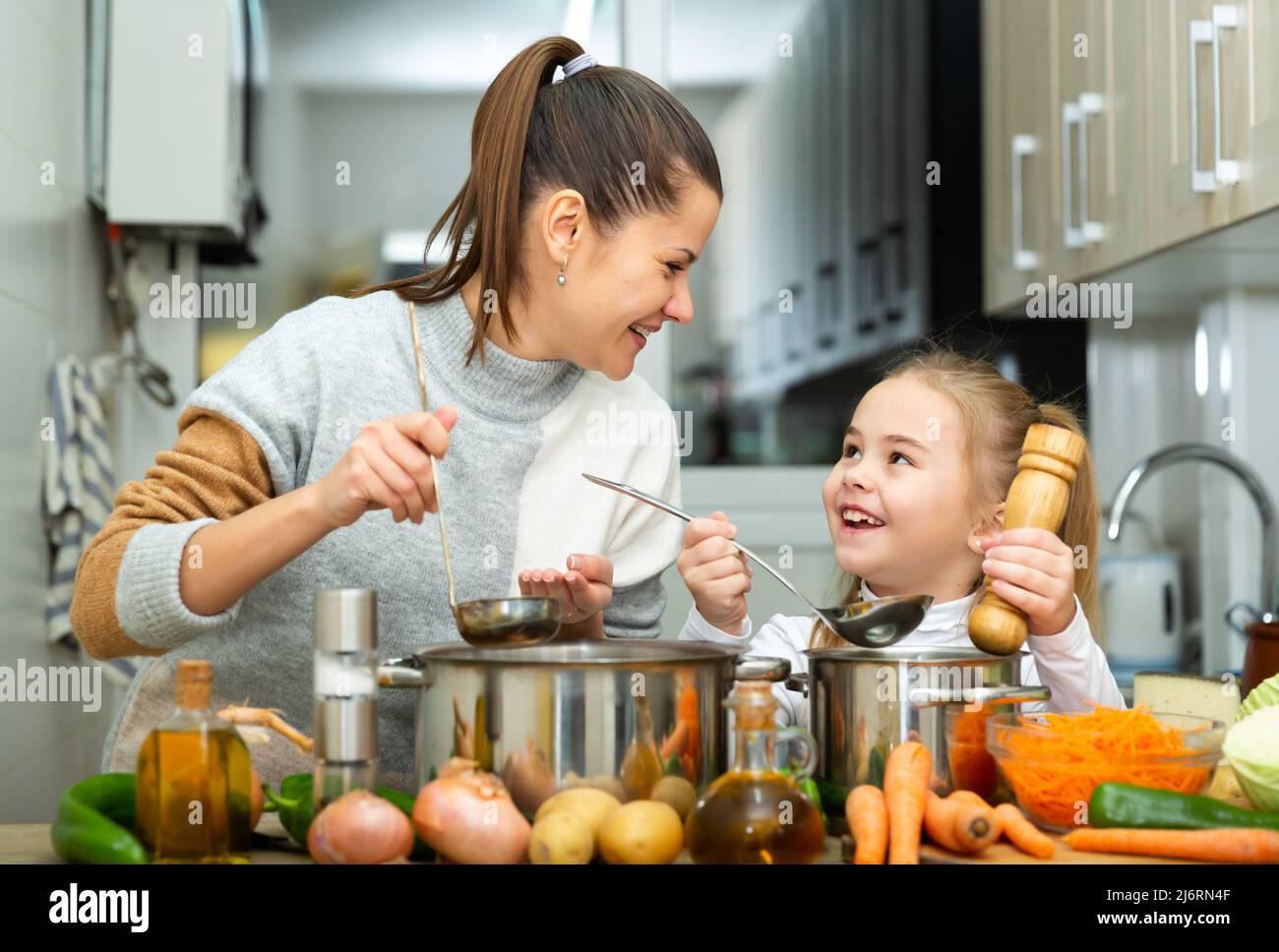 Small girl helping mother soup hi-res stock photography and images - Alamy