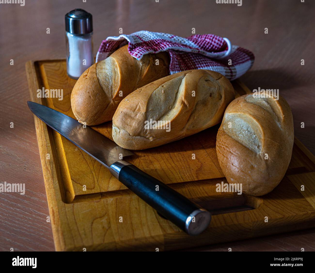 Fresh home-made milk rolls, tasty bread, rolls, all on a cutting board ...