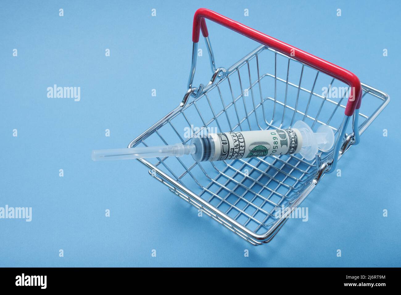 The syringe wrapped in a dollar is in the basket. Offering a financial ...