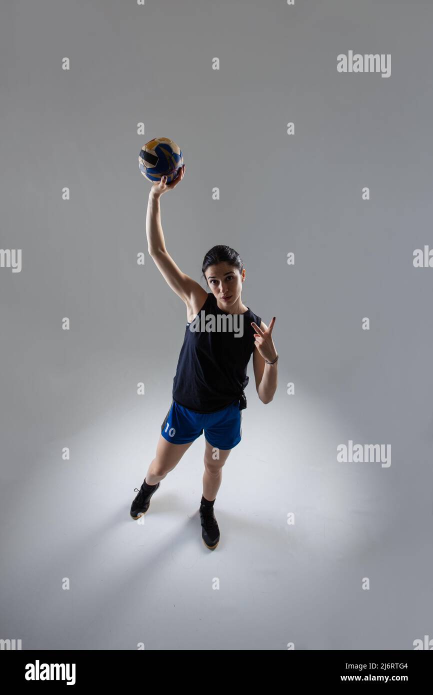Handball player posing on light gray background. Girl posing with ball ...