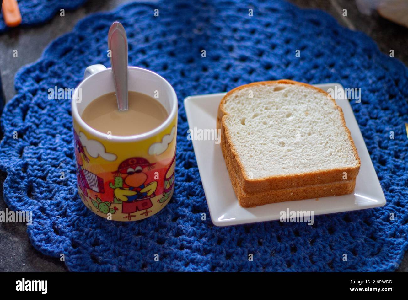 breakfast on a granite table with a white square plate and a colorful ...