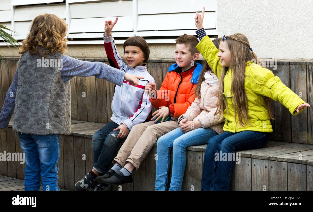 Little kid acting out phrase to friends Stock Photo - Alamy