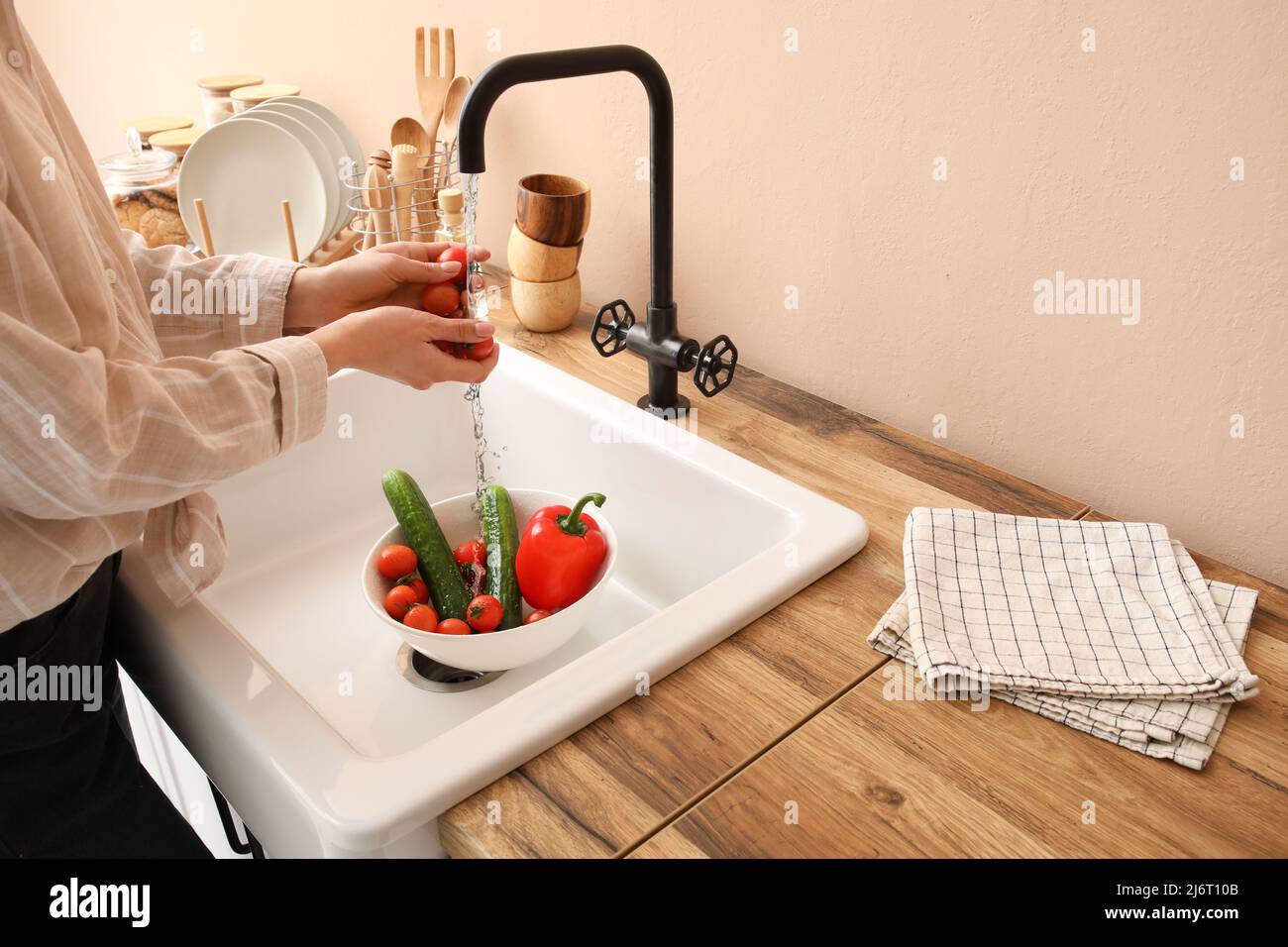 Woman washing fresh vegetables in kitchen sink Stock Photo - Alamy