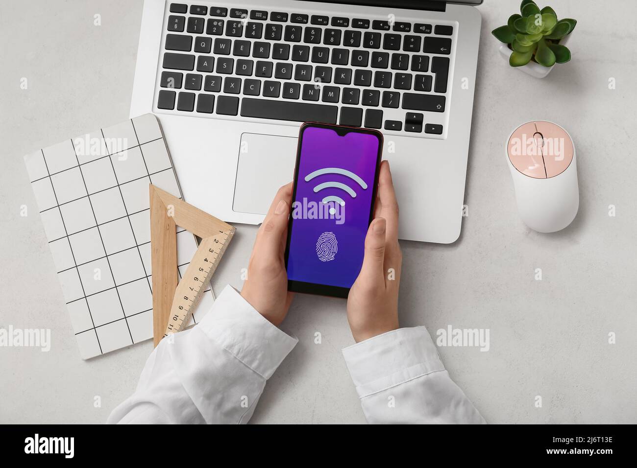 Woman with laptop and smartphone using fingerprint scanner to login ...