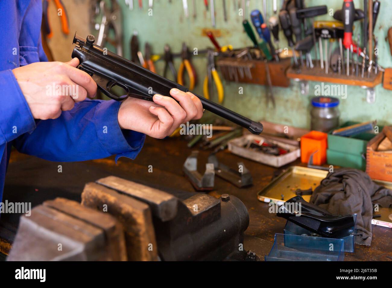 Dismantling and repair of combat pistol in weapons workshop Stock Photo ...