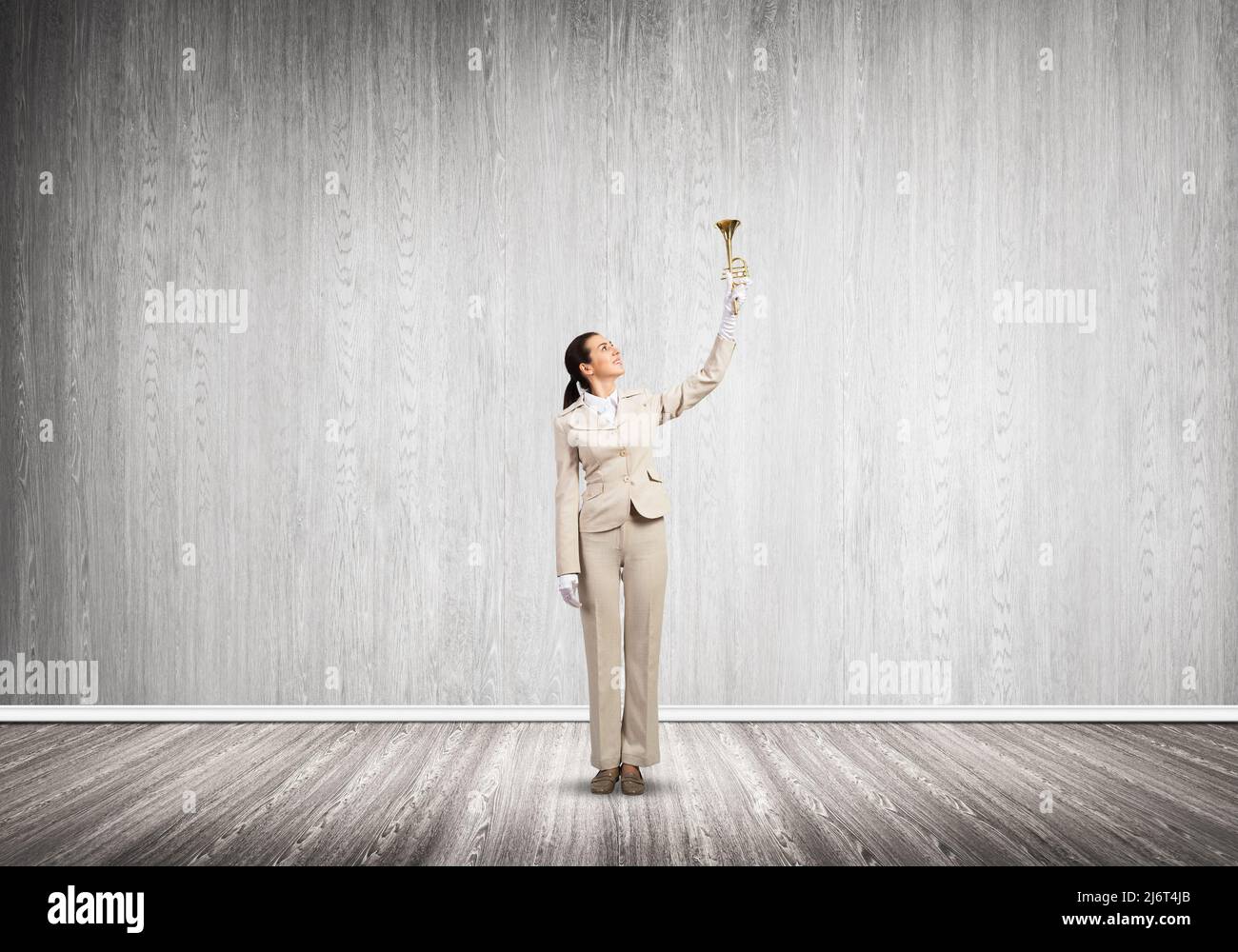 Woman holds trumpet brass instrument over head Stock Photo - Alamy