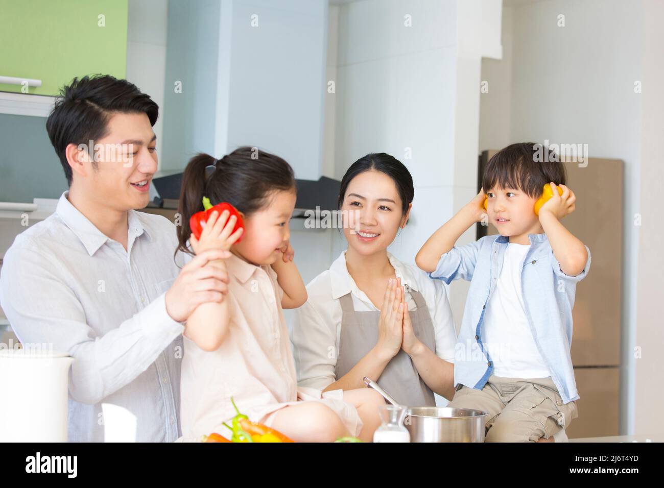 Family kitchen parentage. Young parents are teaching two preschoolers ...