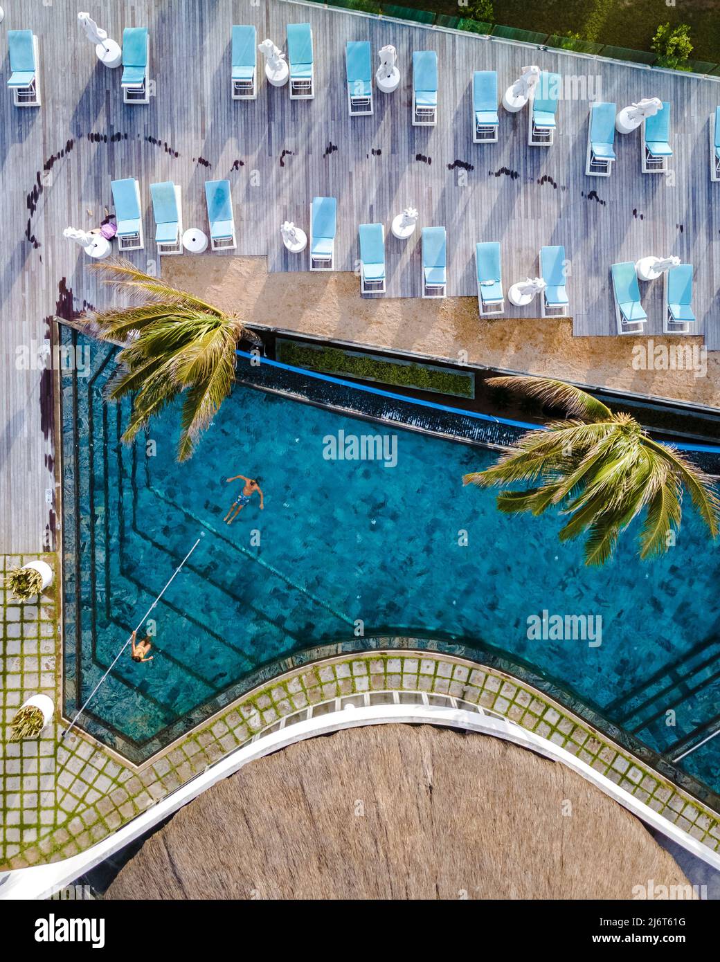 drone aerial view of the tropical swimming pool by a blue ocean. View ...