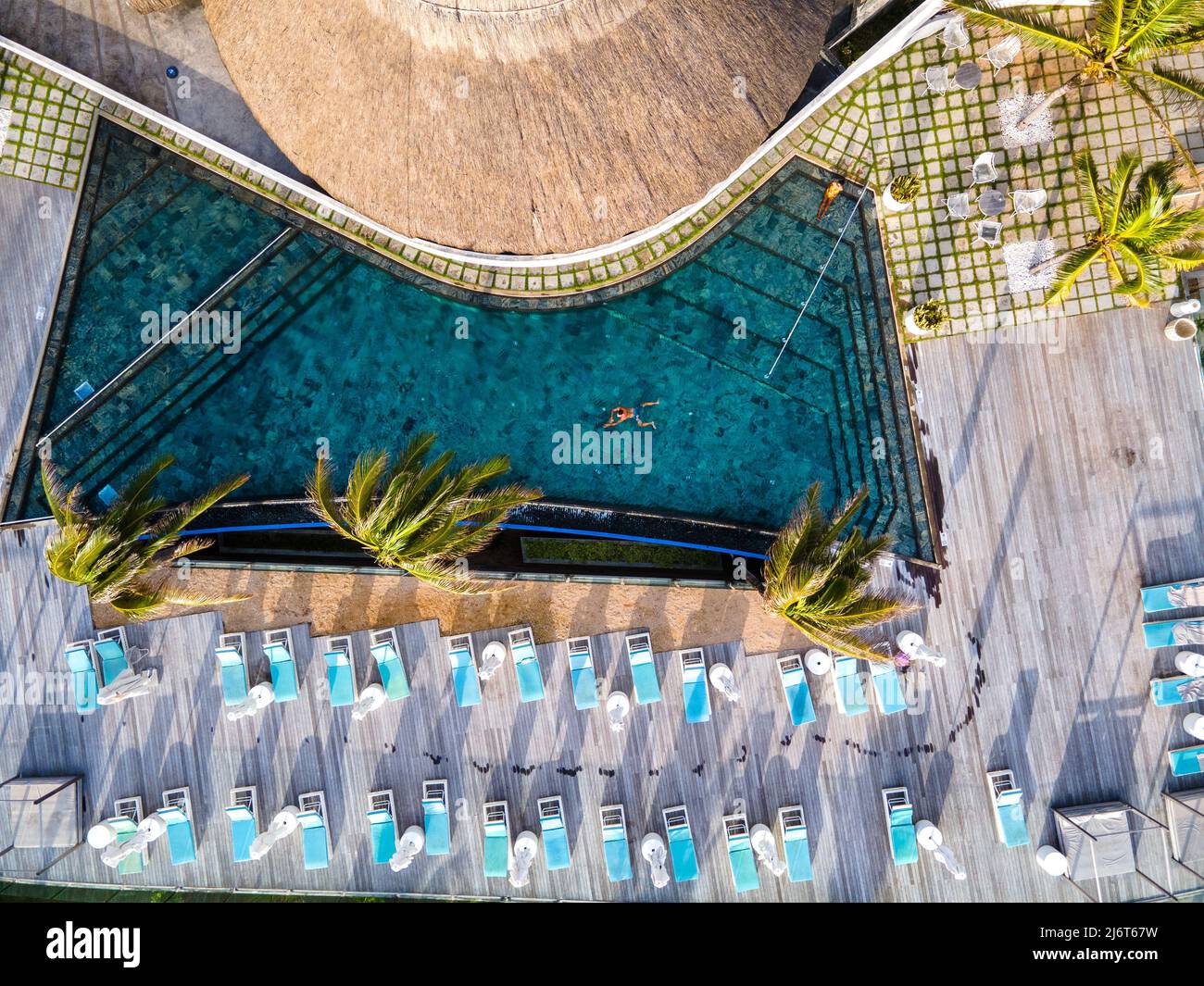drone aerial view of the tropical swimming pool by a blue ocean. View ...