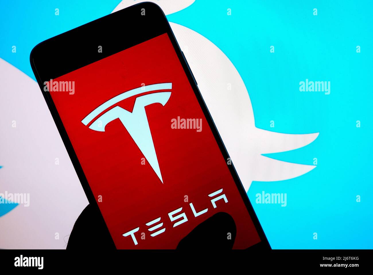 In this photo illustration, a Tesla logo is seen displayed on a ...