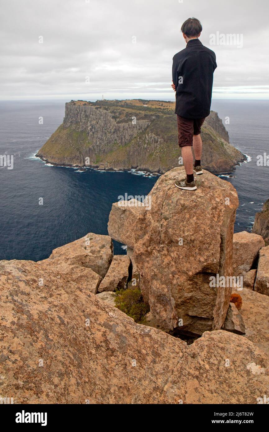 Three Capes Track hiker on Cape Pillar, looking over Tasman Island ...