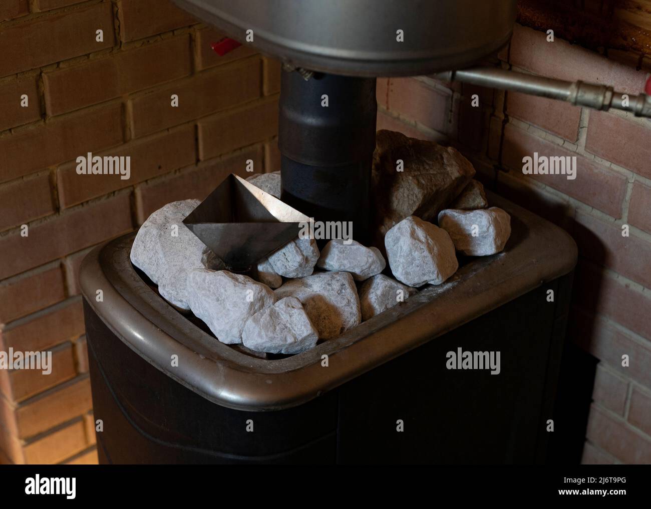 Hot crushed quartz stones lie on top of furnace in sauna spa room Stock ...