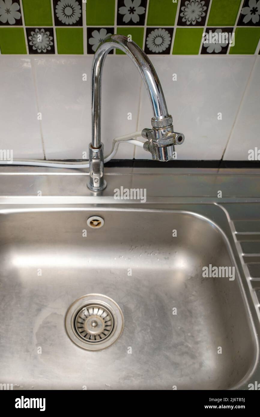 Closeup of the metal sinks with the chrome tap after washing on the ...