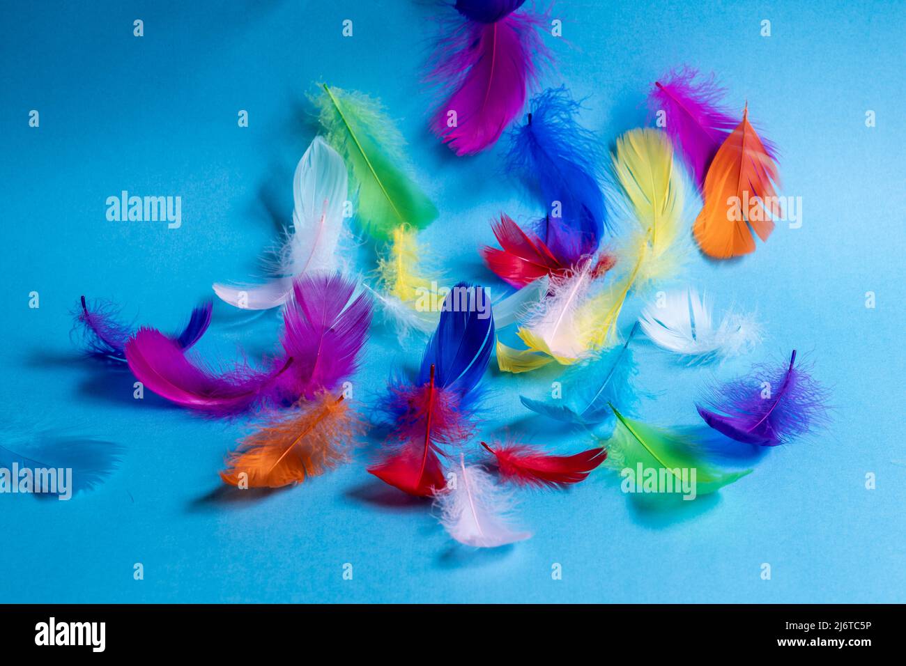 Flying colorful feathers with yellow background flag Stock Photo - Alamy