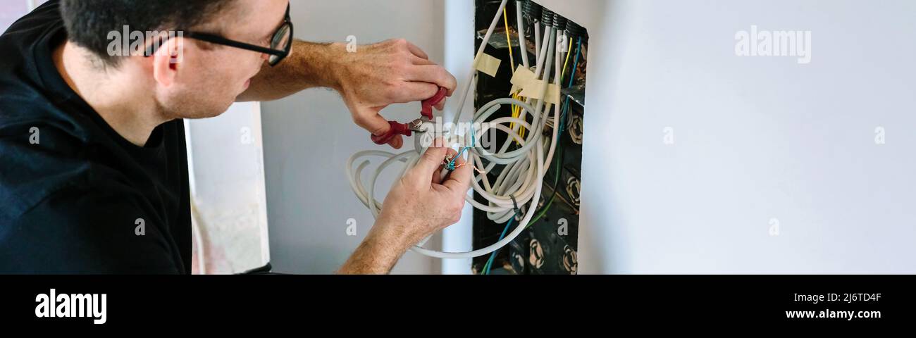 Technician cutting cable to install telecommunication box Stock Photo ...