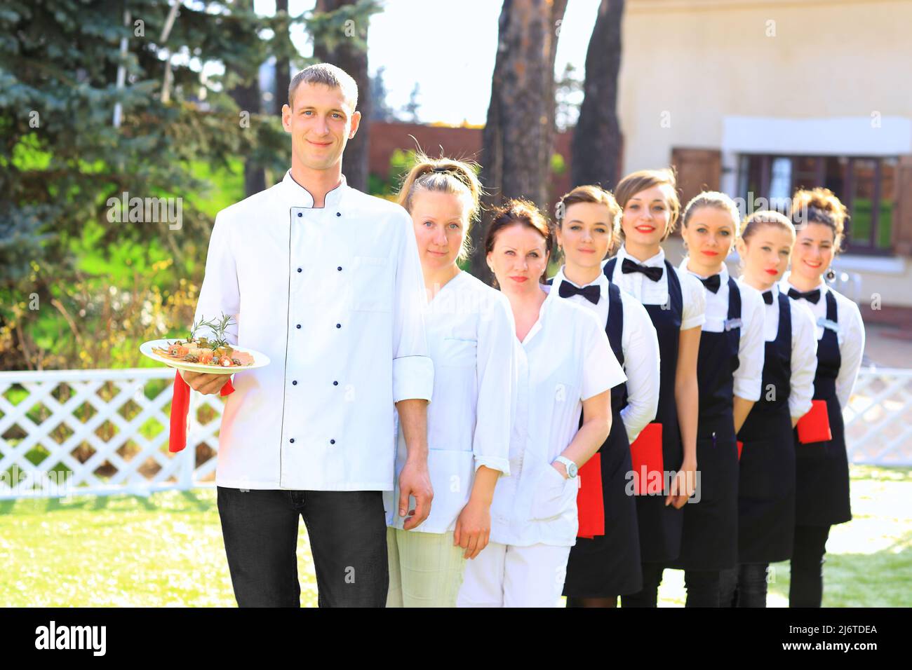Large group of waiters and waitresses standing in row Stock Photo - Alamy