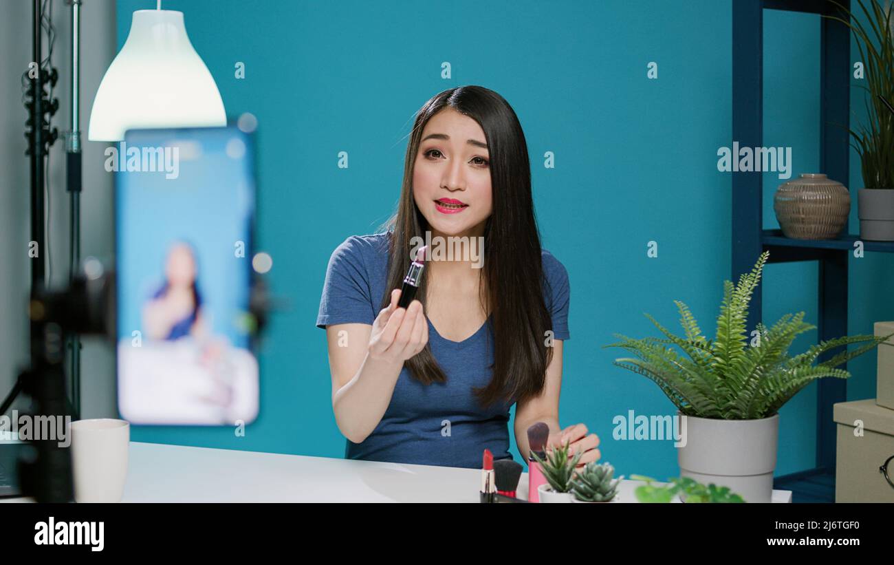 Beauty blogger recording product recommendation on camera, filming ...