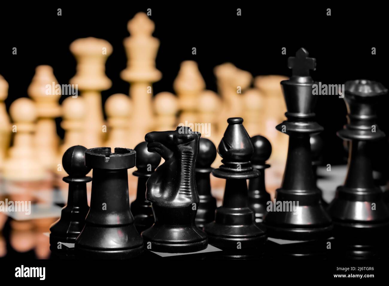 Close up of Chess pieces on a reflective mirror board surface with a ...