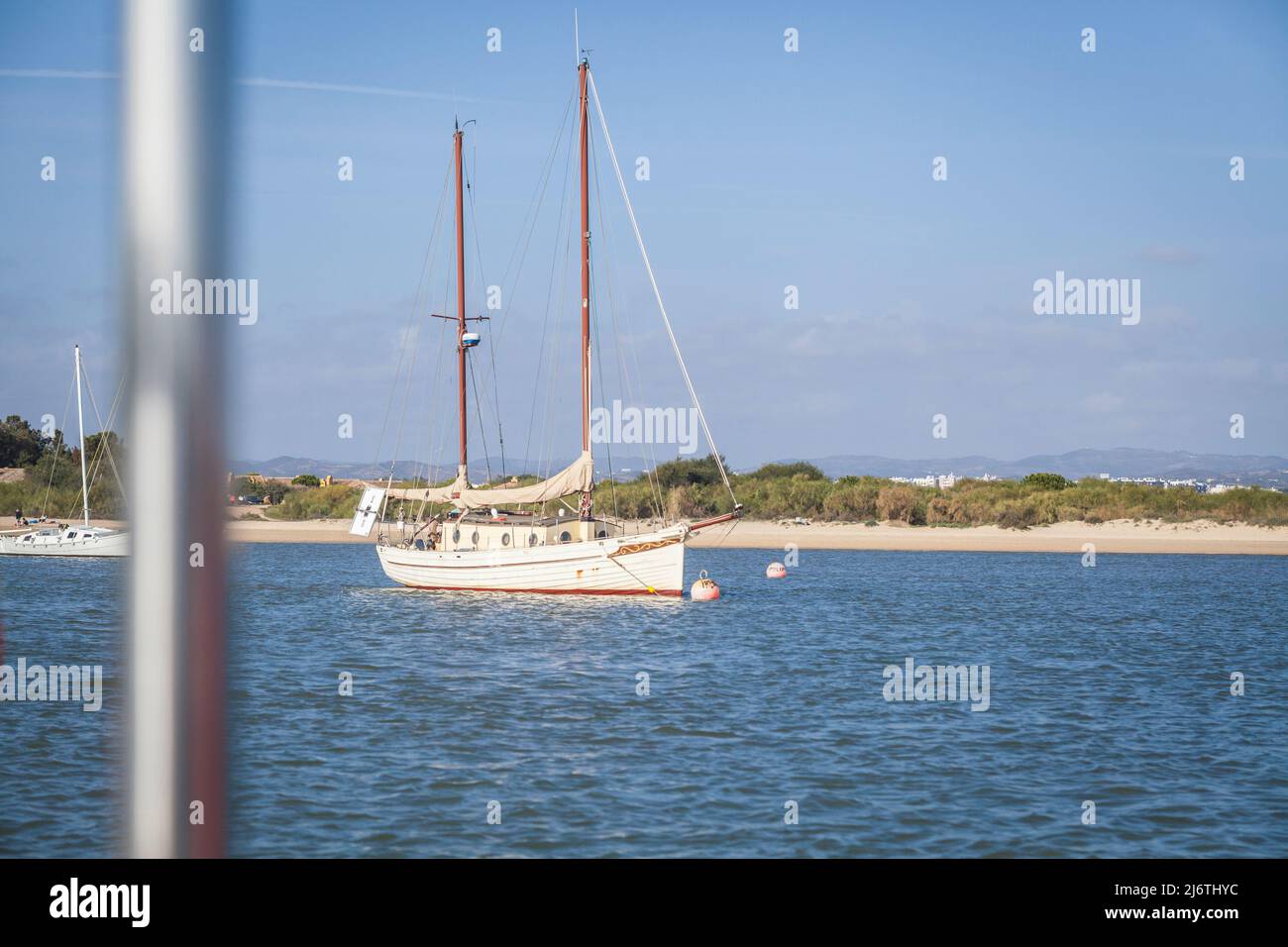large sailing ship with two masts is anchored in the ria farmosa nature ...