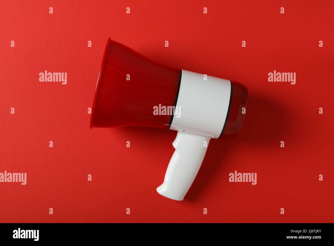 Red and white megaphone on red background Stock Photo - Alamy