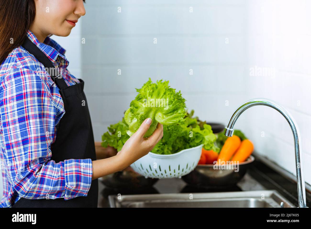 asian girl wash vegetables in the kitchen Stock Photo - Alamy