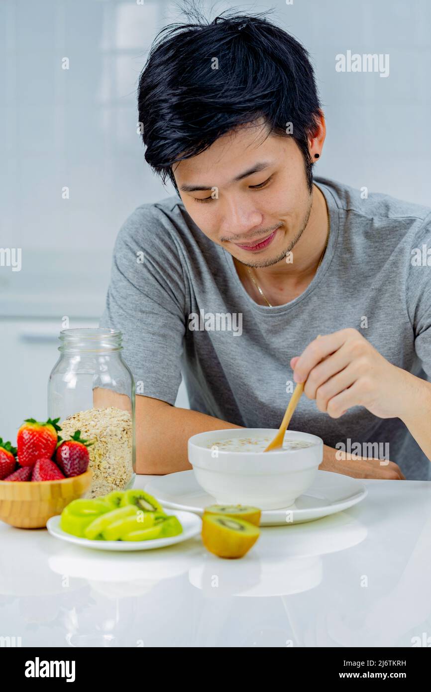 Asian man eating oatmeal for breakfast Stock Photo - Alamy