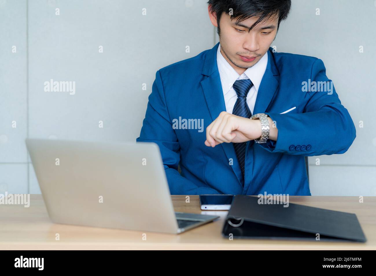 Busy businessman looking at wristwatch, In business time is important ...