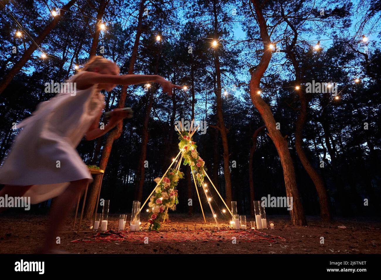 Festive string lights illumination on boho tipi arch decor on outdoor ...