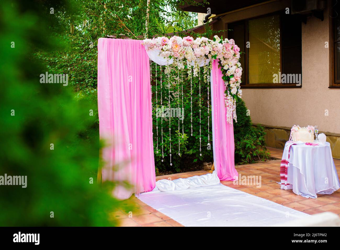 Wedding arch decorated with cloth and flowers outdoors. Beautiful ...