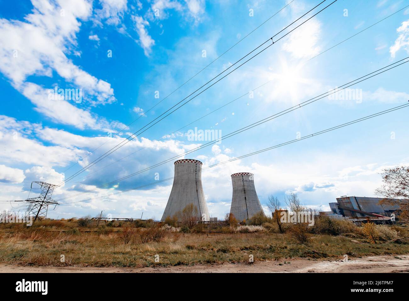 Nuclear power plant with steaming cooling towers under blue summer sky ...