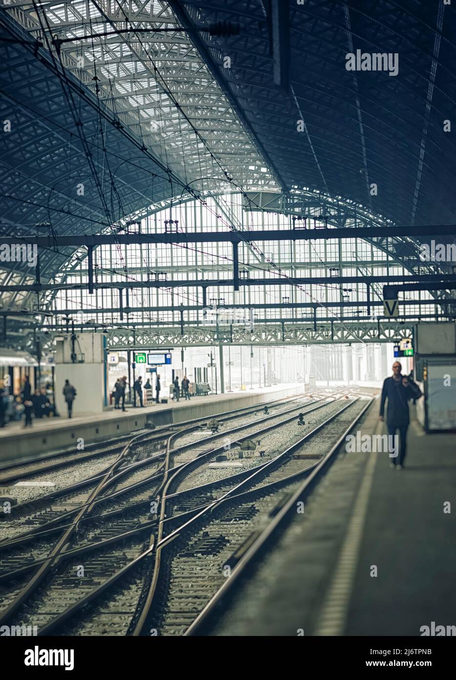 Man walking in terminal along railway Stock Photo - Alamy